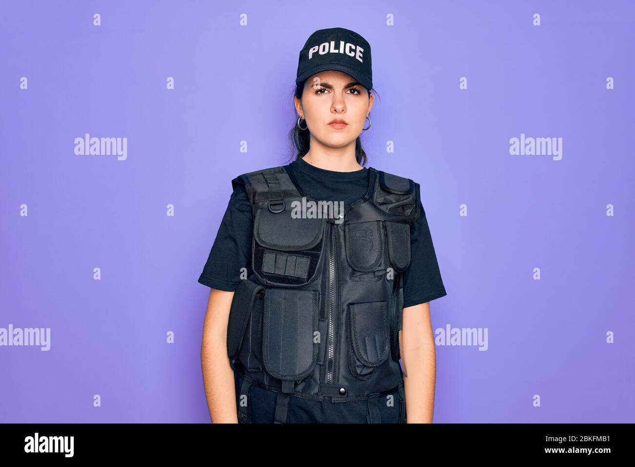 Young police woman wearing security bulletproof vest uniform over ...