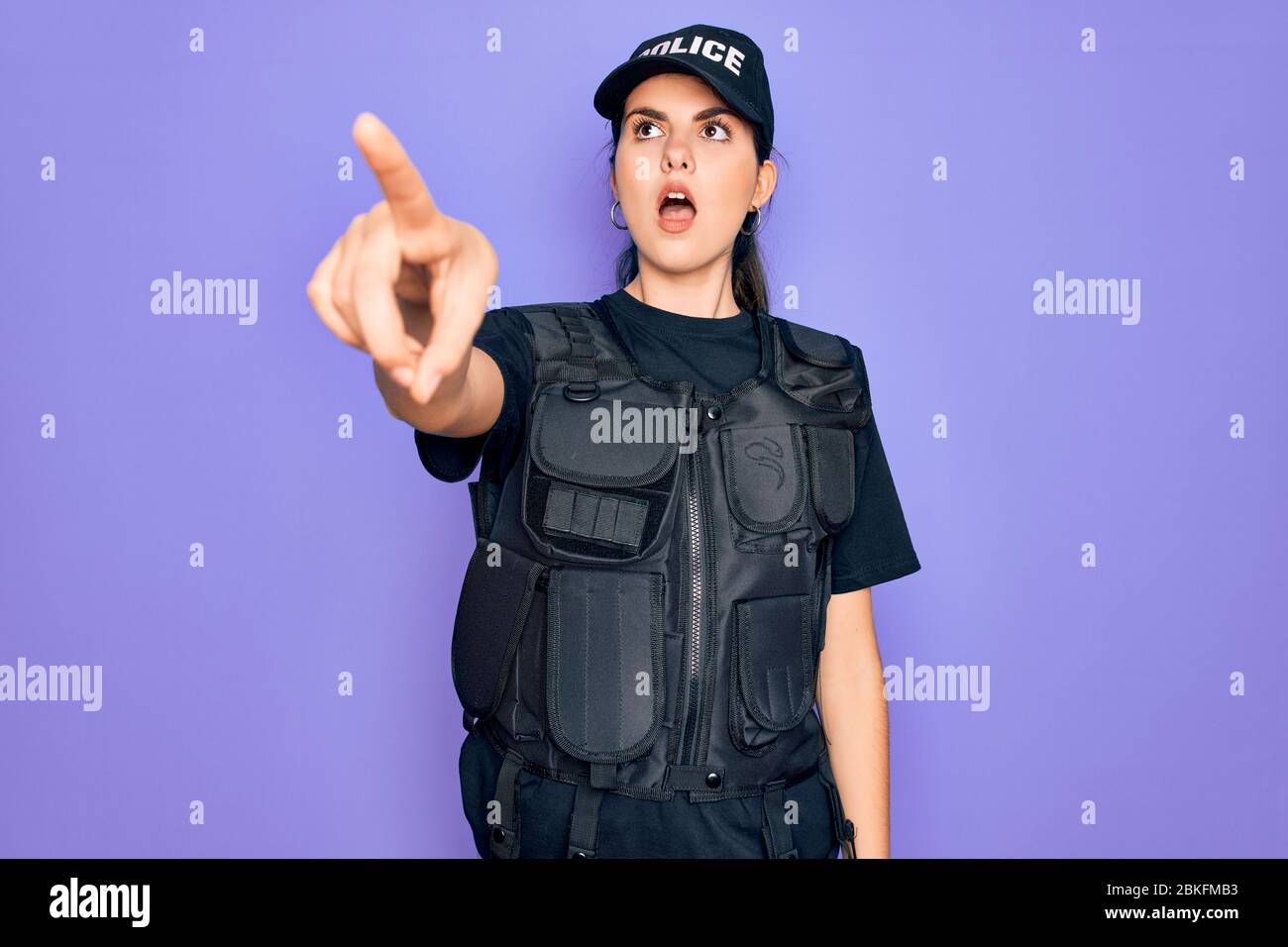 Young police woman wearing security bulletproof vest uniform over ...