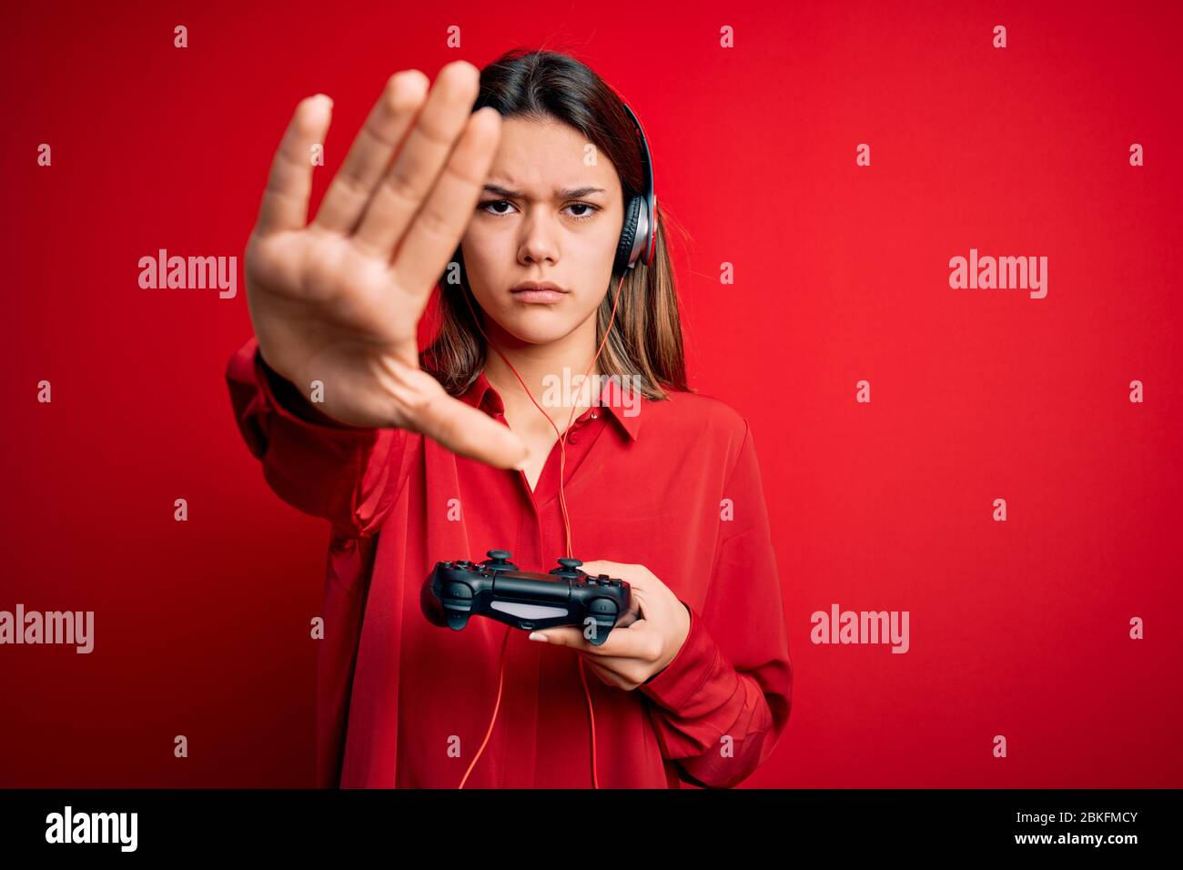 Young beautiful brunette gamer girl playing video game using joystick ...