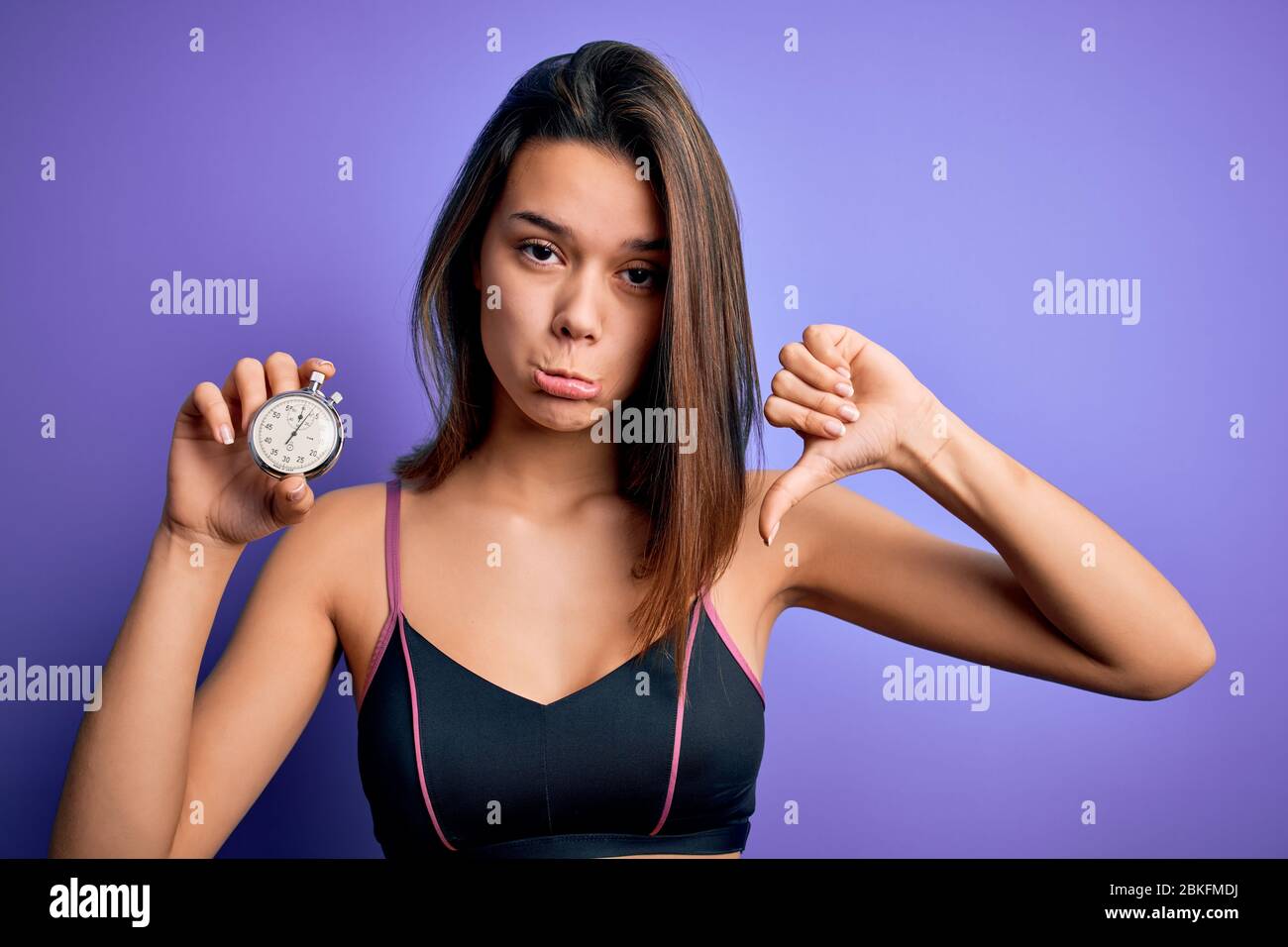 Young beautiful sporty girl doing sport using stopwatch over isolated ...