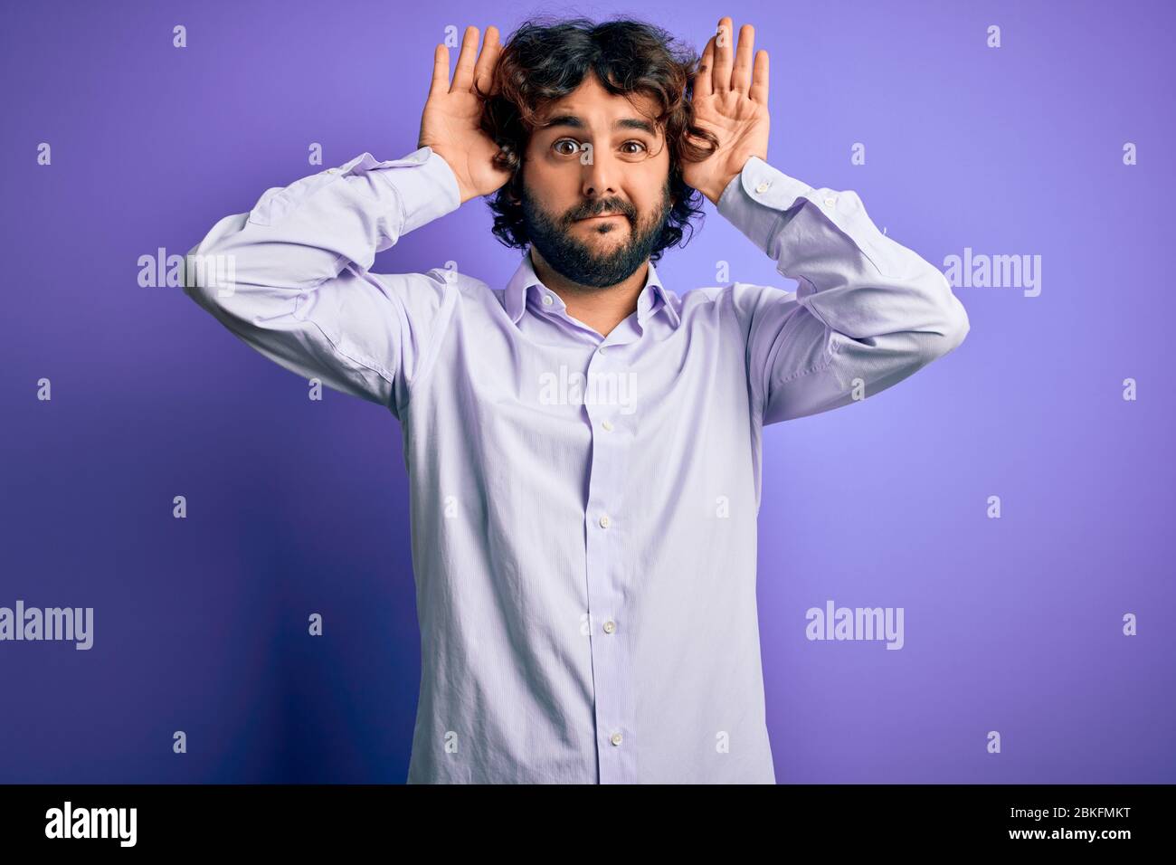 Young handsome business man with beard wearing shirt standing over ...