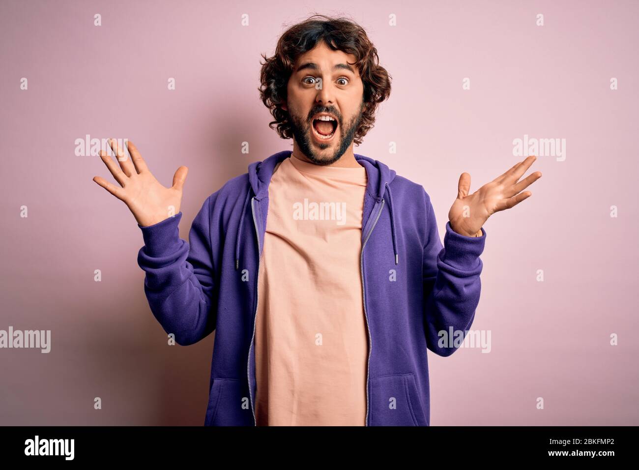 Young handsome sporty man with beard wearing casual sweatshirt over ...