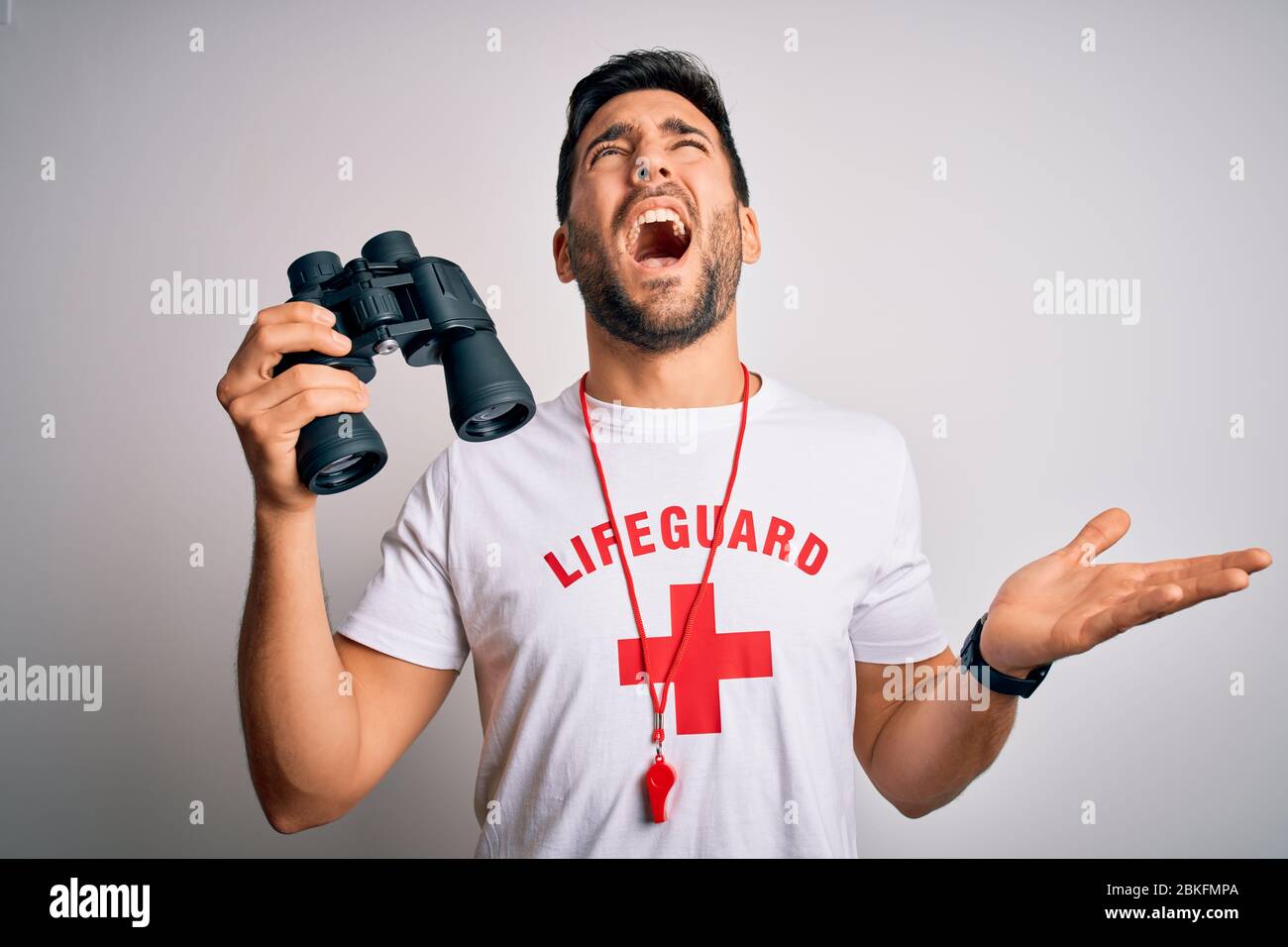 Young lifeguard man with beard wearing t-shirt with red cross and ...