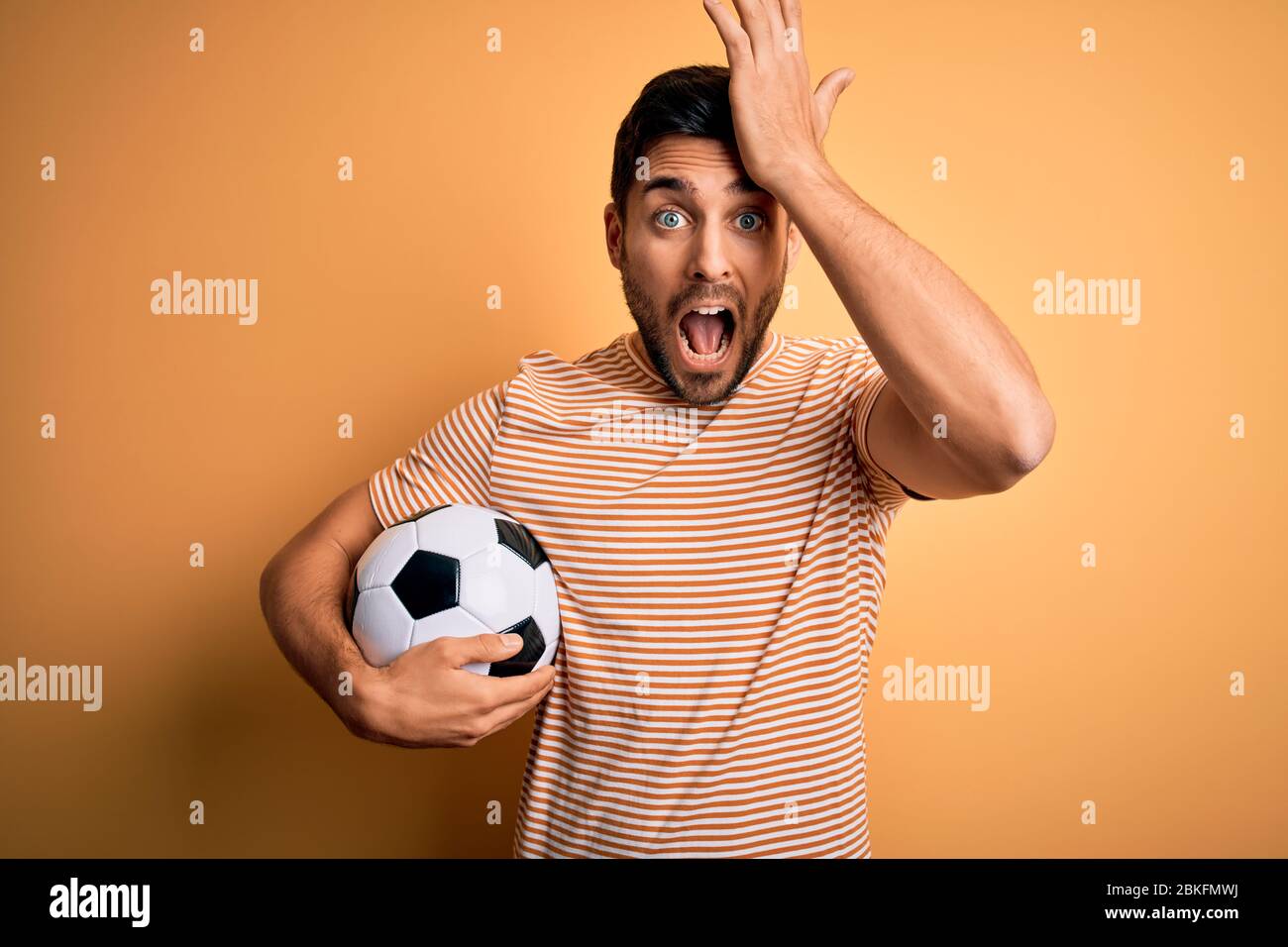 Handsome player man with beard playing soccer holding footballl ball ...