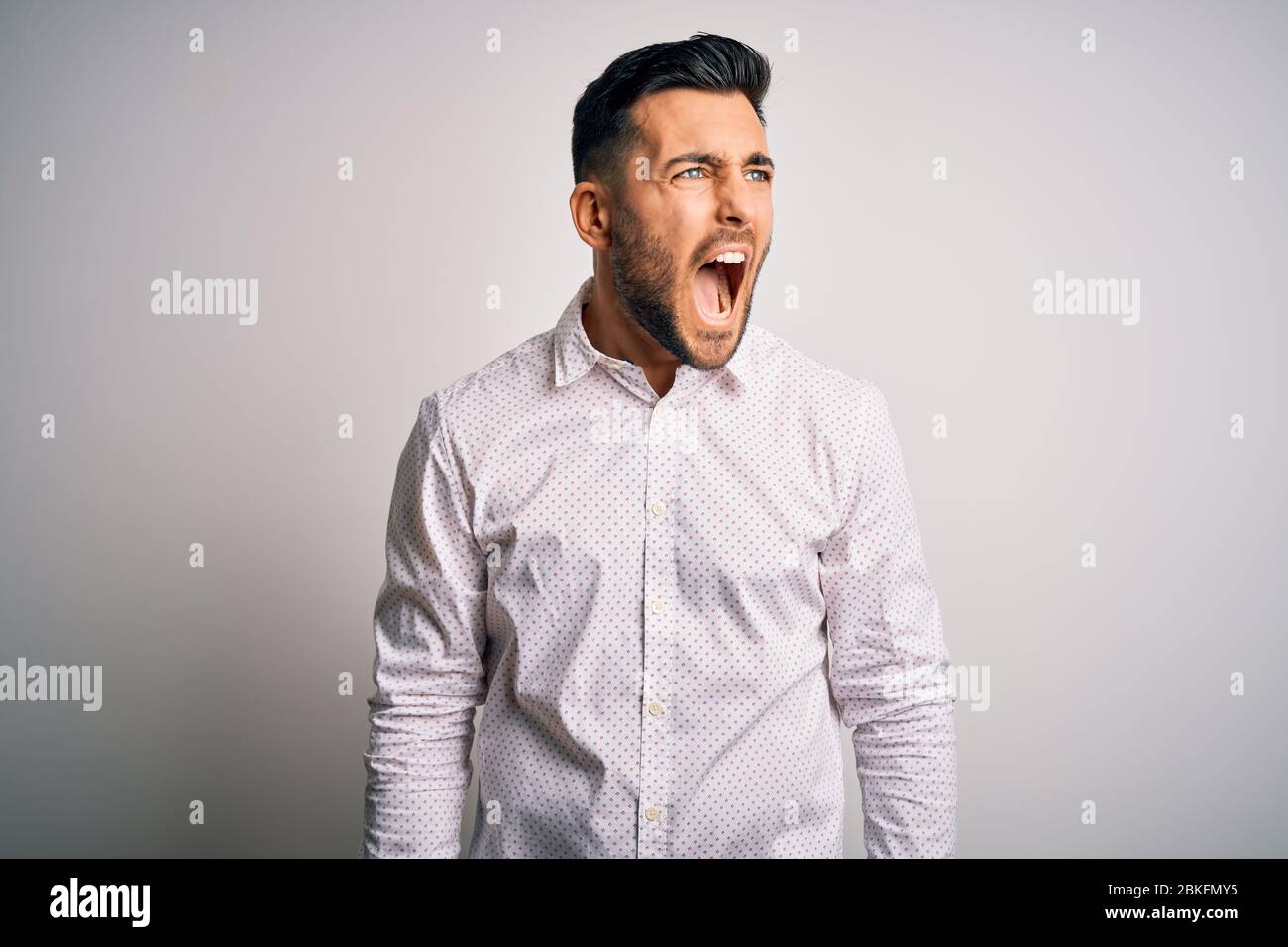 Young handsome man wearing elegant shirt standing over isolated white ...