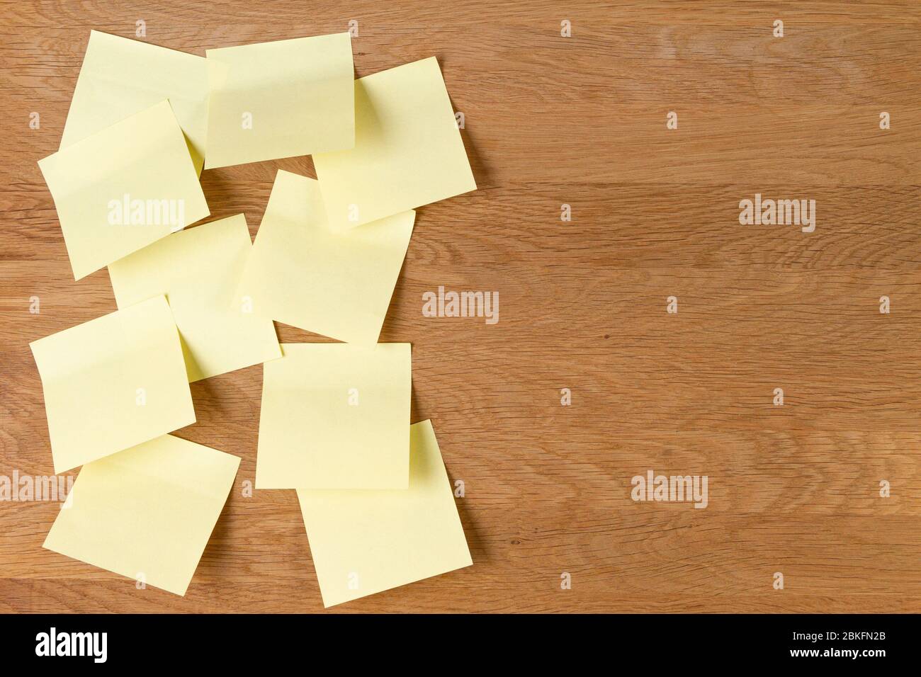 Sticky notes. Blank yellow square paper stickers on natural wooden ...