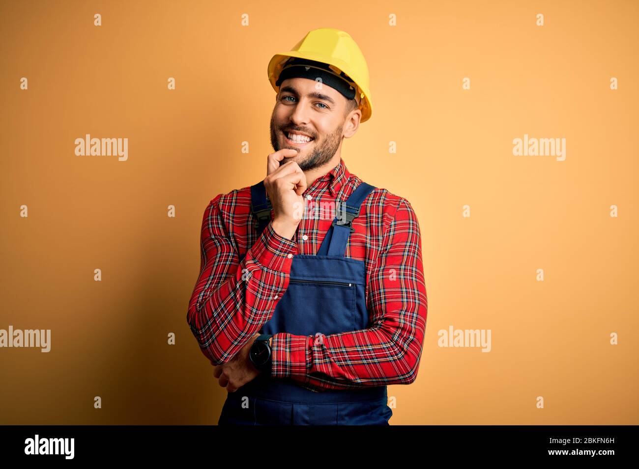 Young builder man wearing construction uniform and safety helmet over ...