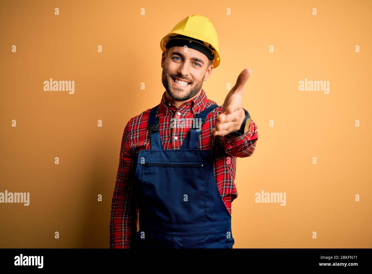 Young builder man wearing construction uniform and safety helmet over ...