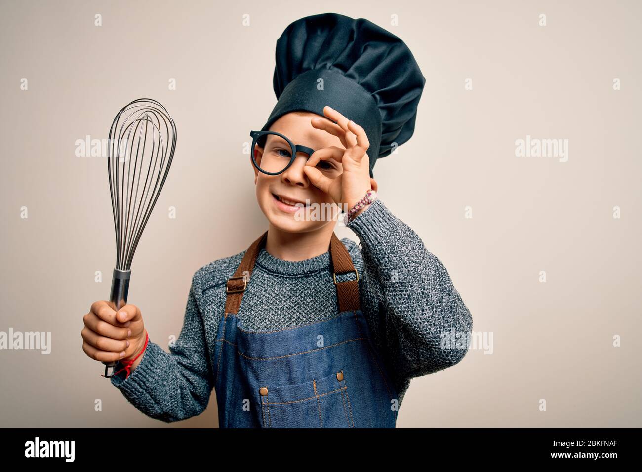 Young little caucasian cook kid wearing chef uniform and hat using ...
