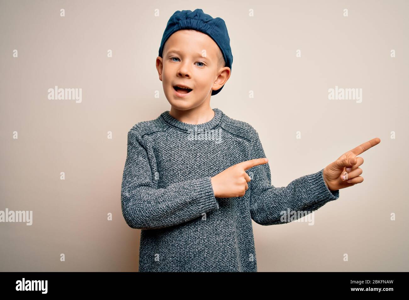 Young little caucasian kid with blue eyes wearing wool cap over ...