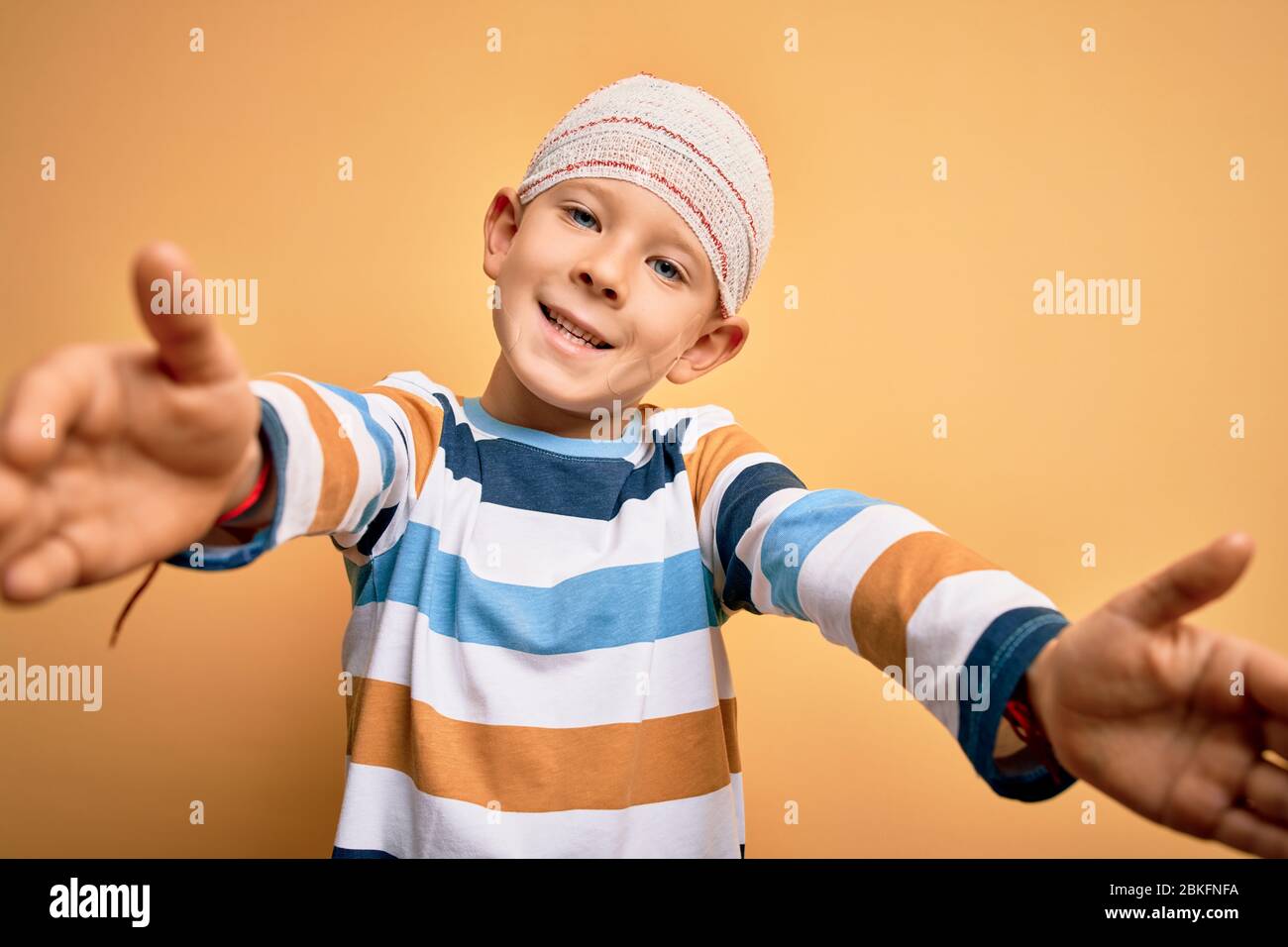 Young little caucasian kid injured wearing medical bandage on head over ...
