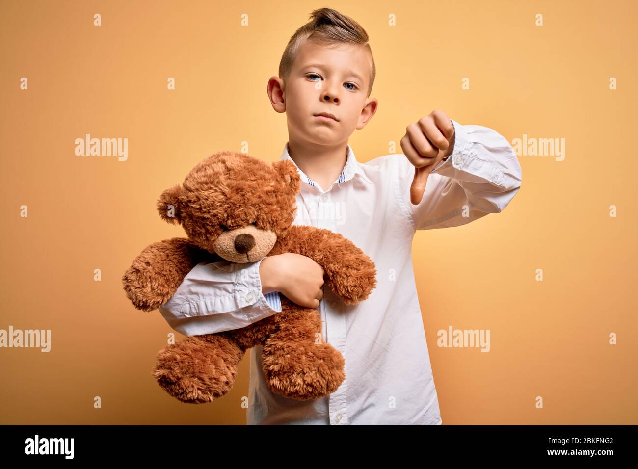 Young little caucasian kid hugging teddy bear stuffed animal over ...