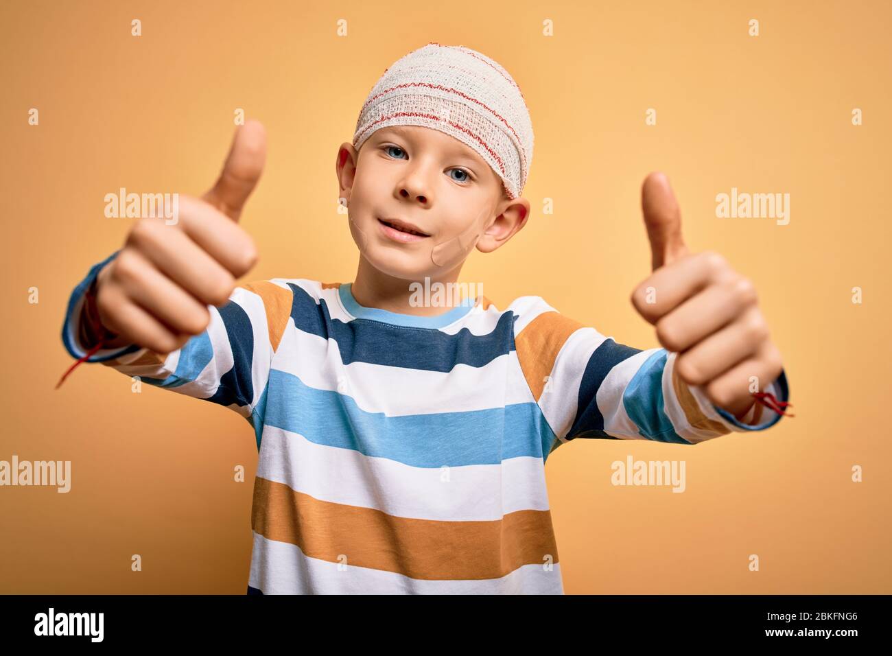 Young little caucasian kid injured wearing medical bandage on head over ...