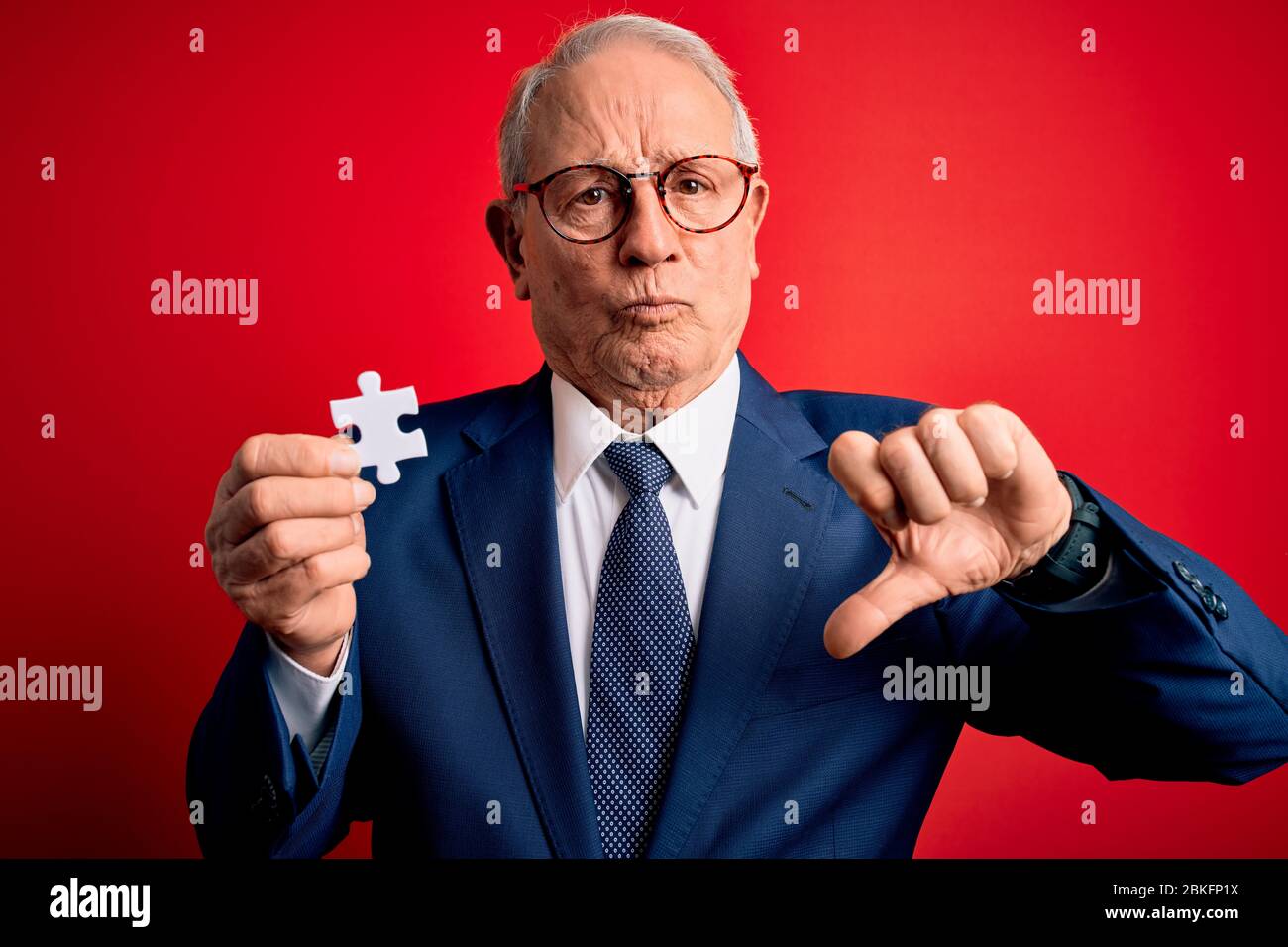 Grey haired senior business man holding puzzle piece as union and ...