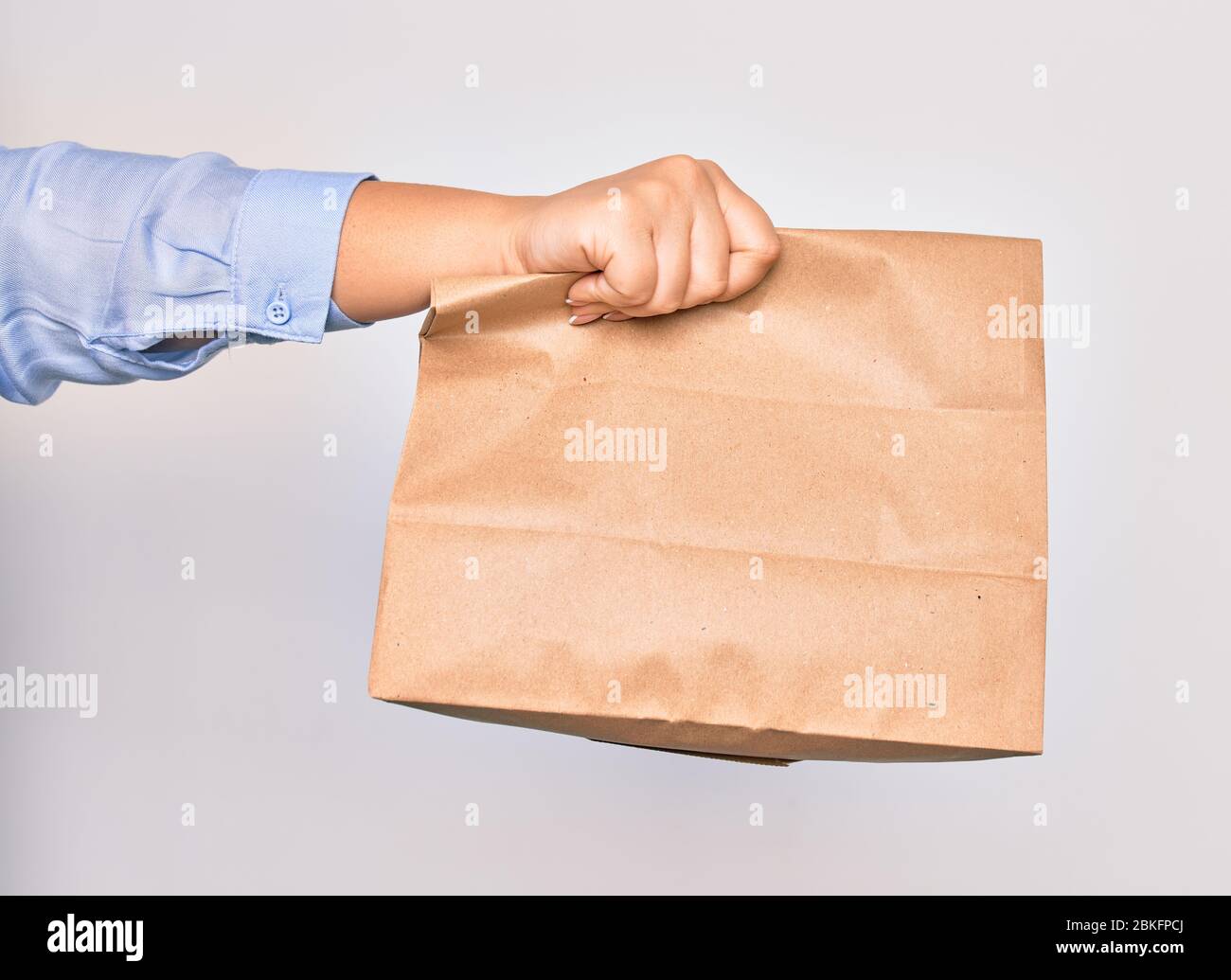 Hand of caucasian young woman holding deliver paper bag of takeaway ...