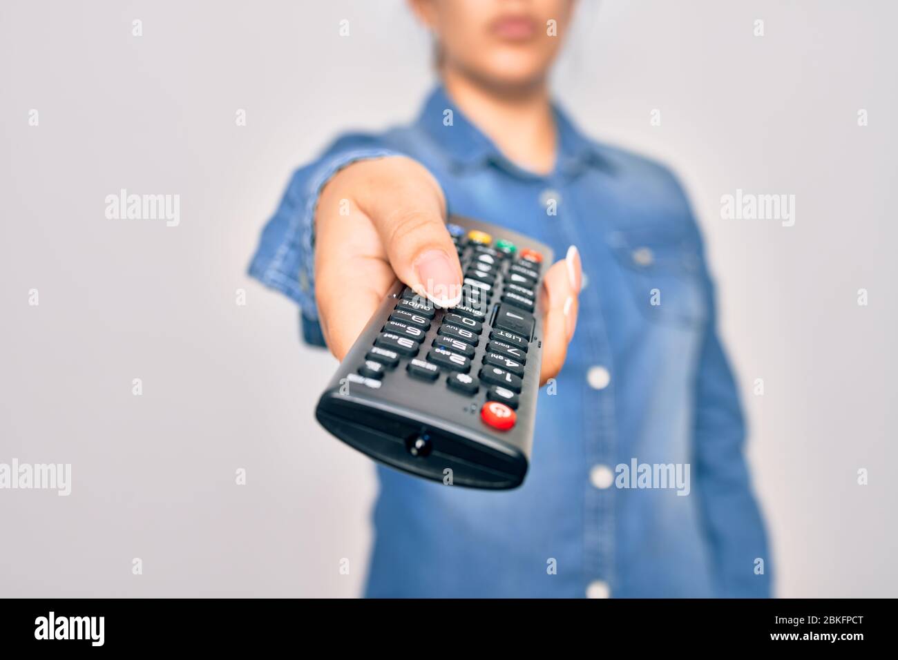 Woman changing television channel holding tv remote control. Standing ...