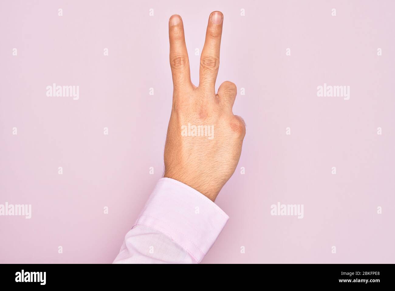 Hand of caucasian young man showing fingers over isolated pink ...