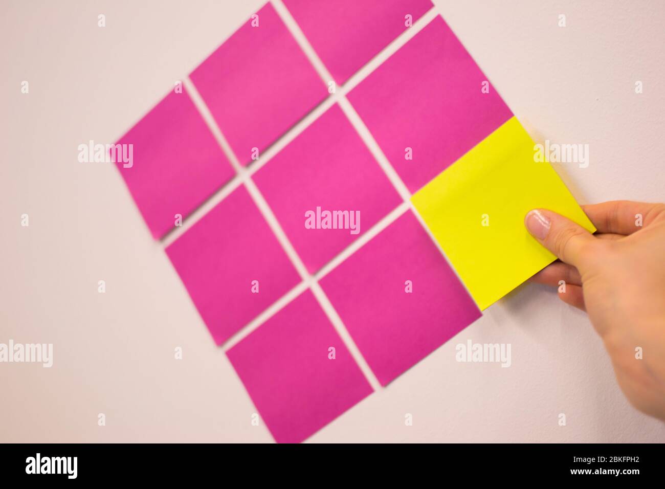 8 pink sticky notes and a yellow speech bubble are located on the wall ...