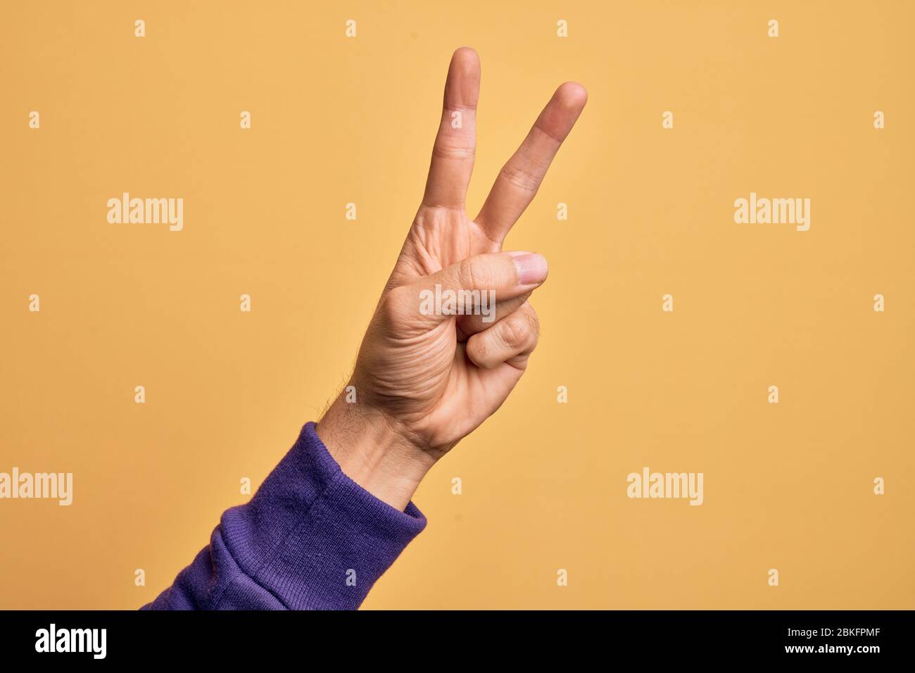 Hand of caucasian young man showing fingers over isolated yellow ...