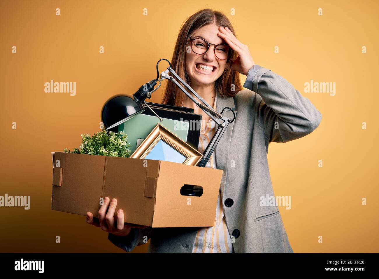 Young beautiful redhead businesswoman fired holding carboard box over ...