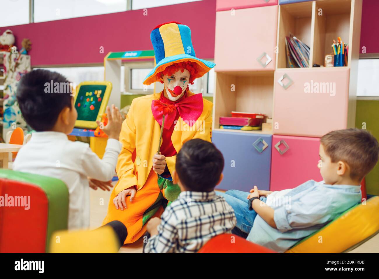 Funny clown play with cheerful children together Stock Photo - Alamy