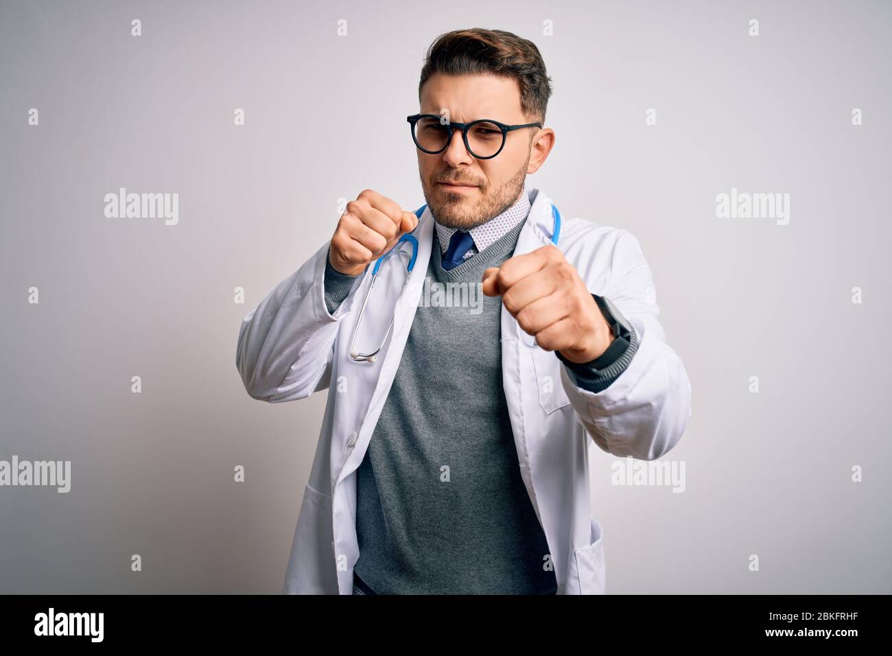 Young doctor man with blue eyes wearing medical coat and stethoscope ...