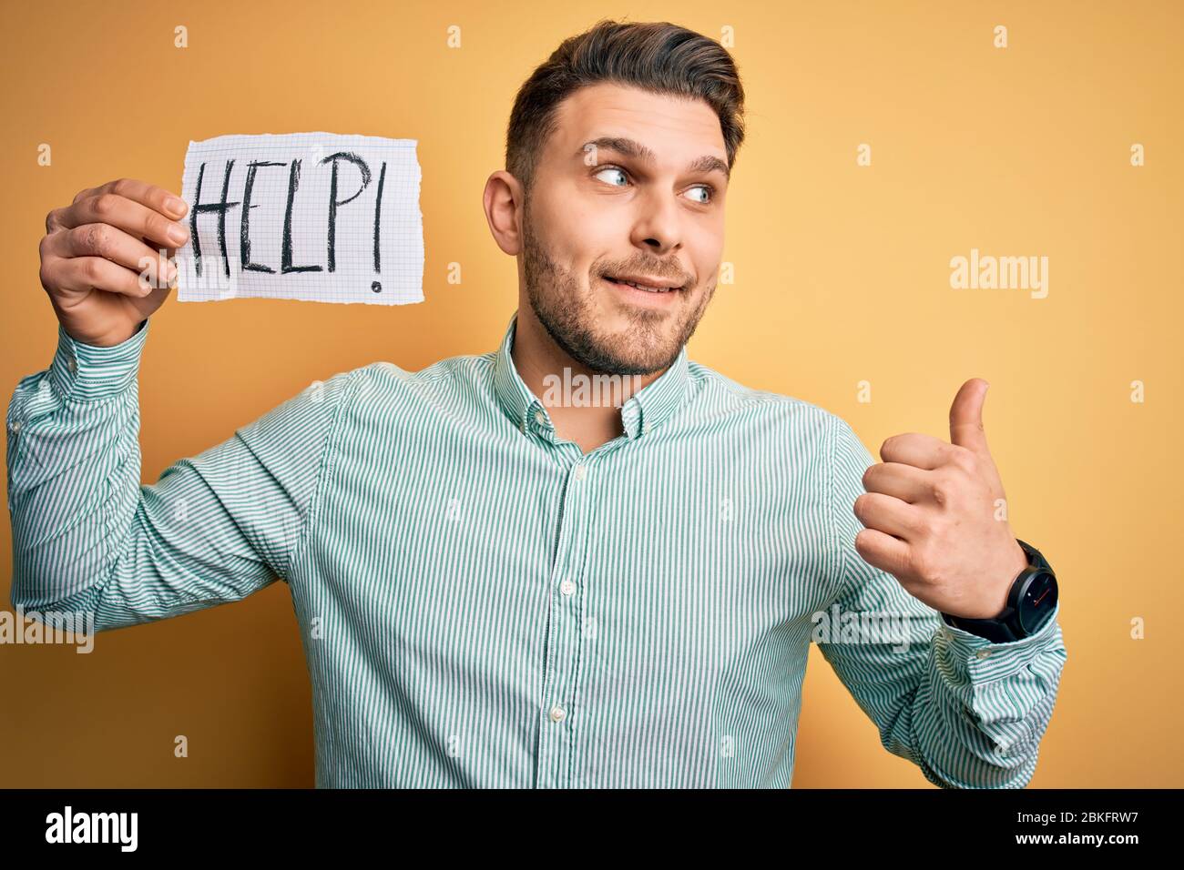 Young business man with blue eyes asking for help holding paper note ...