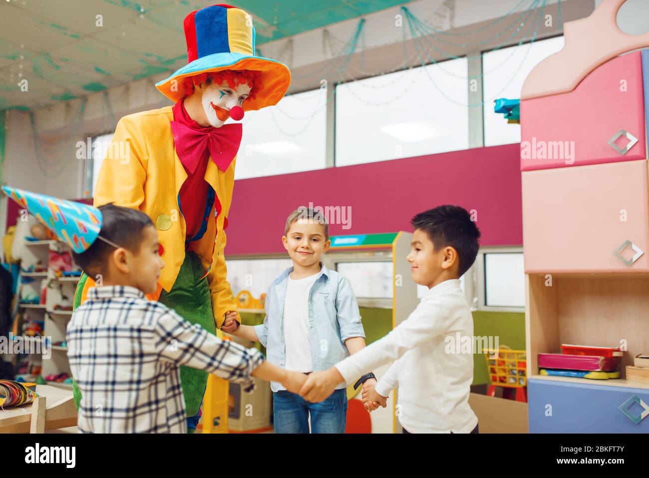 Clown with cheerful children play counting game Stock Photo - Alamy
