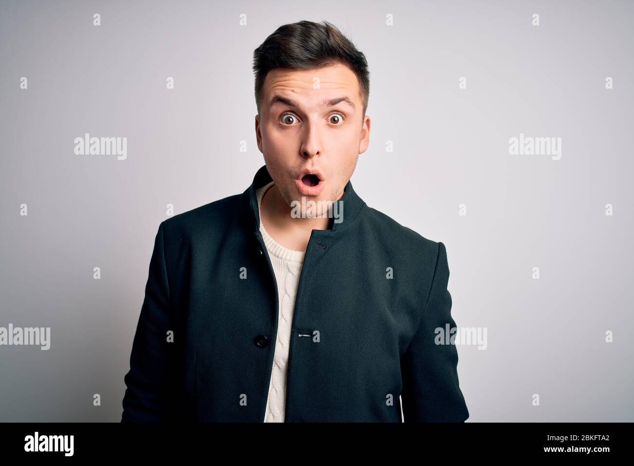 Young handsome business mas wearing elegant winter coat standing over ...