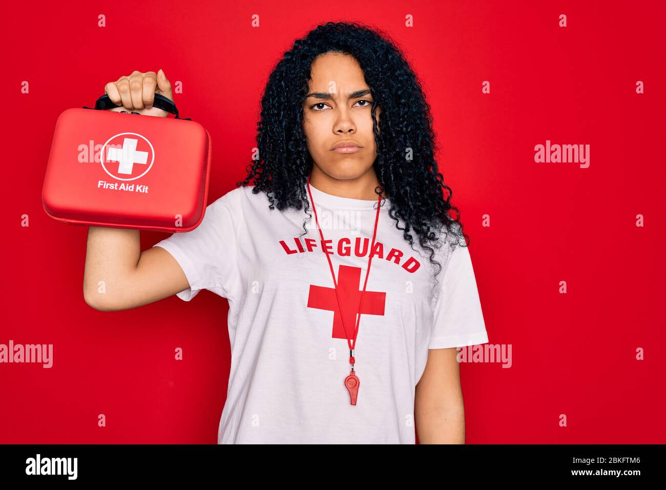Young african american curly lifeguard woman wearing whistle holding ...