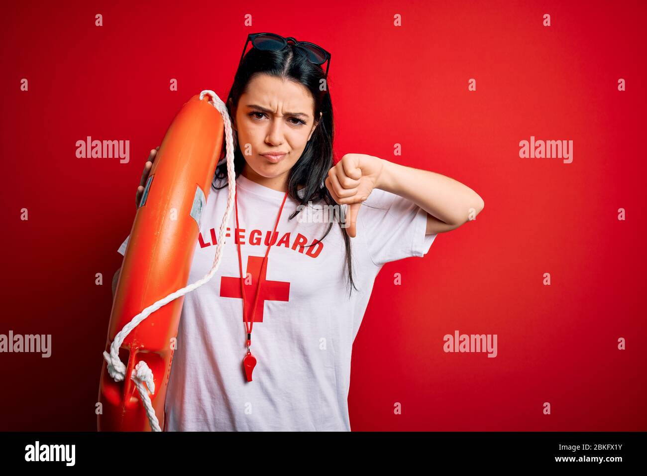 Young lifeguard woman wearing secury guard equipent holding rescue ...