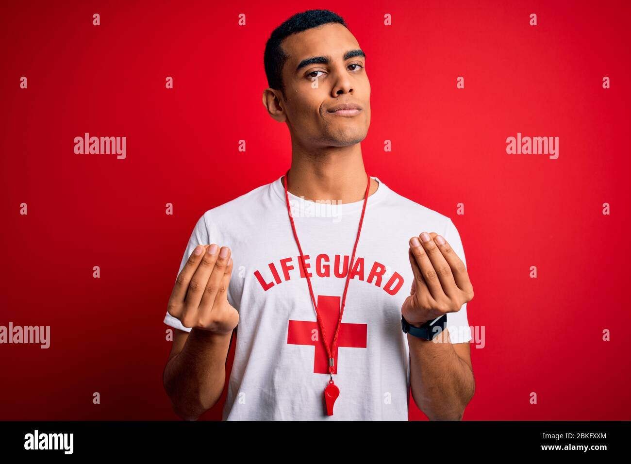 Young handsome african american lifeguard man wearing t-shirt with red ...