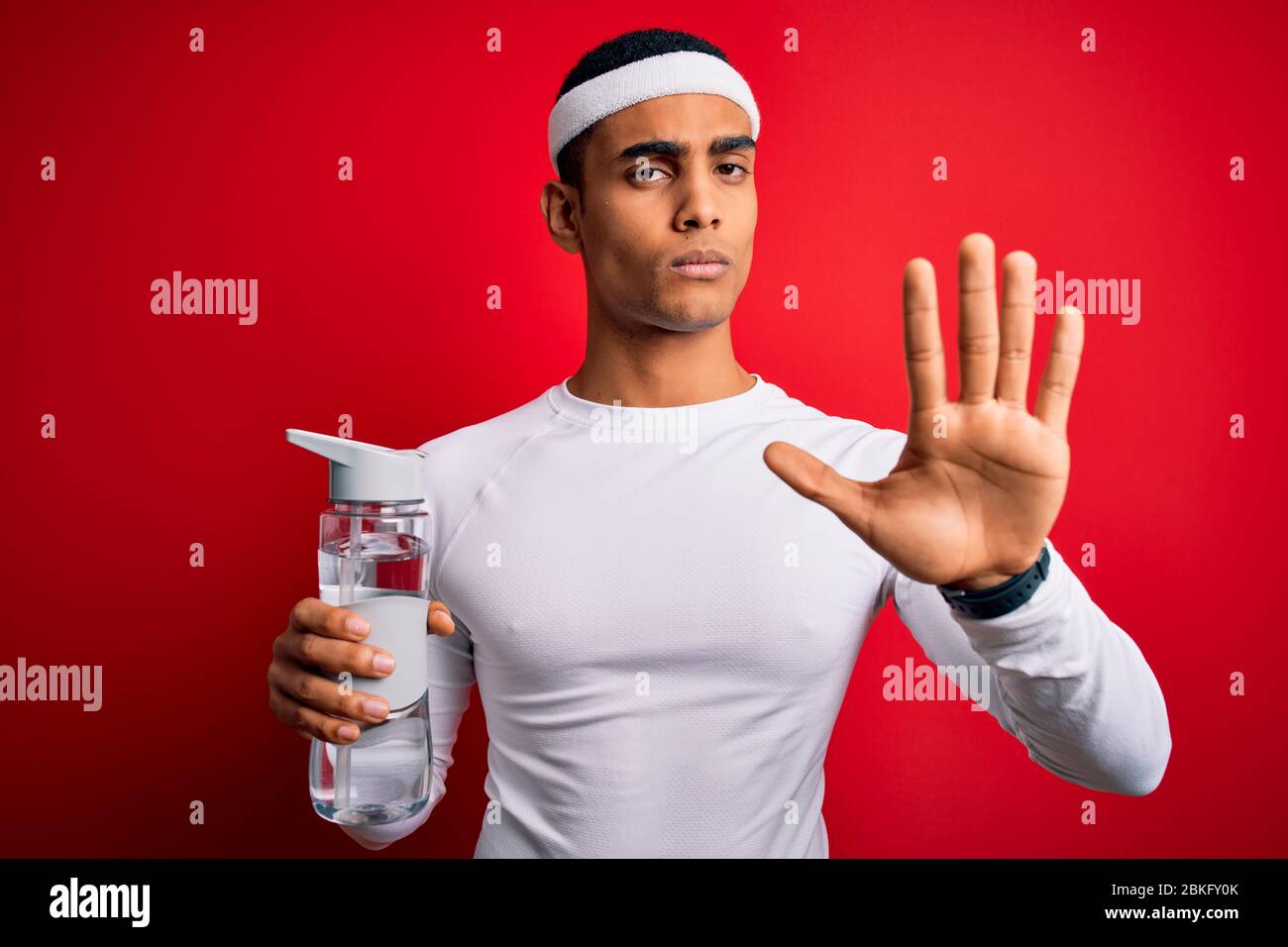 Young handsome african american sportsman wearing sportswear drinking ...