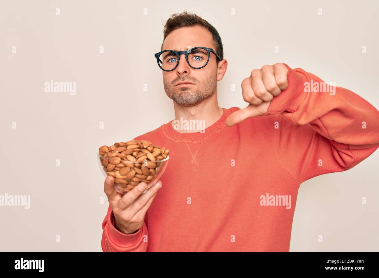 Handsome man with blue eyes holding bowl with healthy almonds snack ...