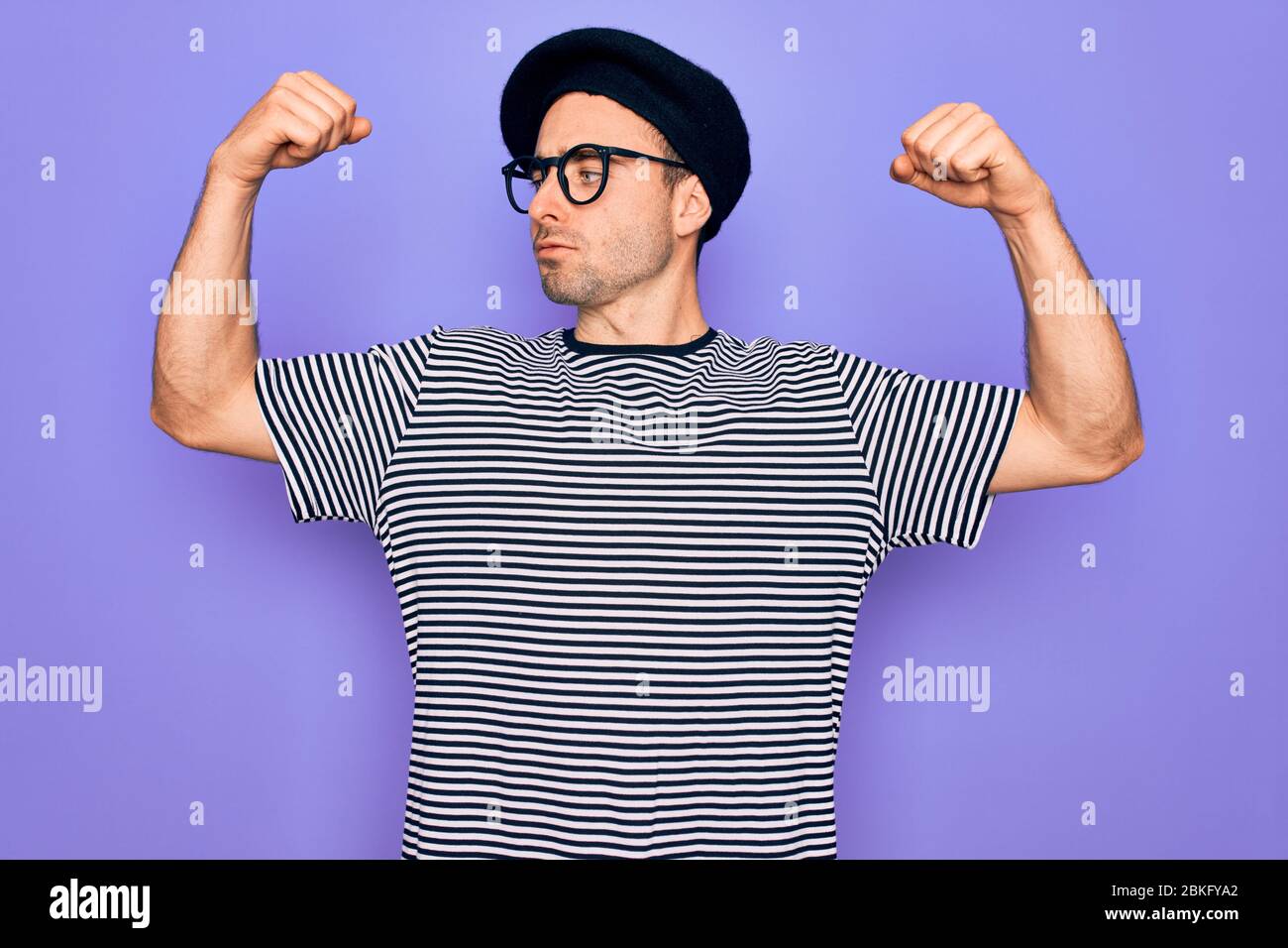 Handsome man with blue eyes wearing striped t-shirt and french beret ...