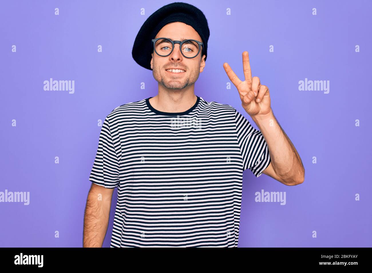 Handsome man with blue eyes wearing striped t-shirt and french beret ...