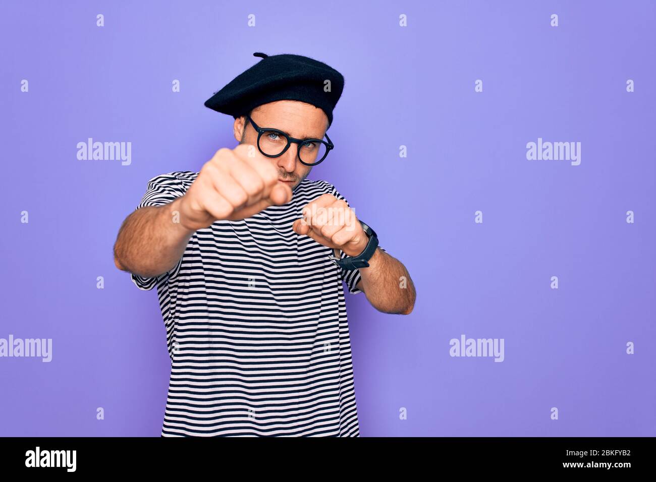 Handsome man with blue eyes wearing striped t-shirt and french beret ...
