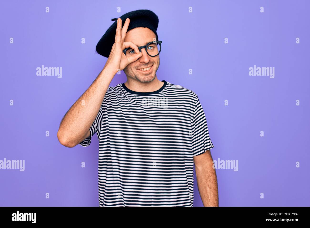Handsome man with blue eyes wearing striped t-shirt and french beret ...
