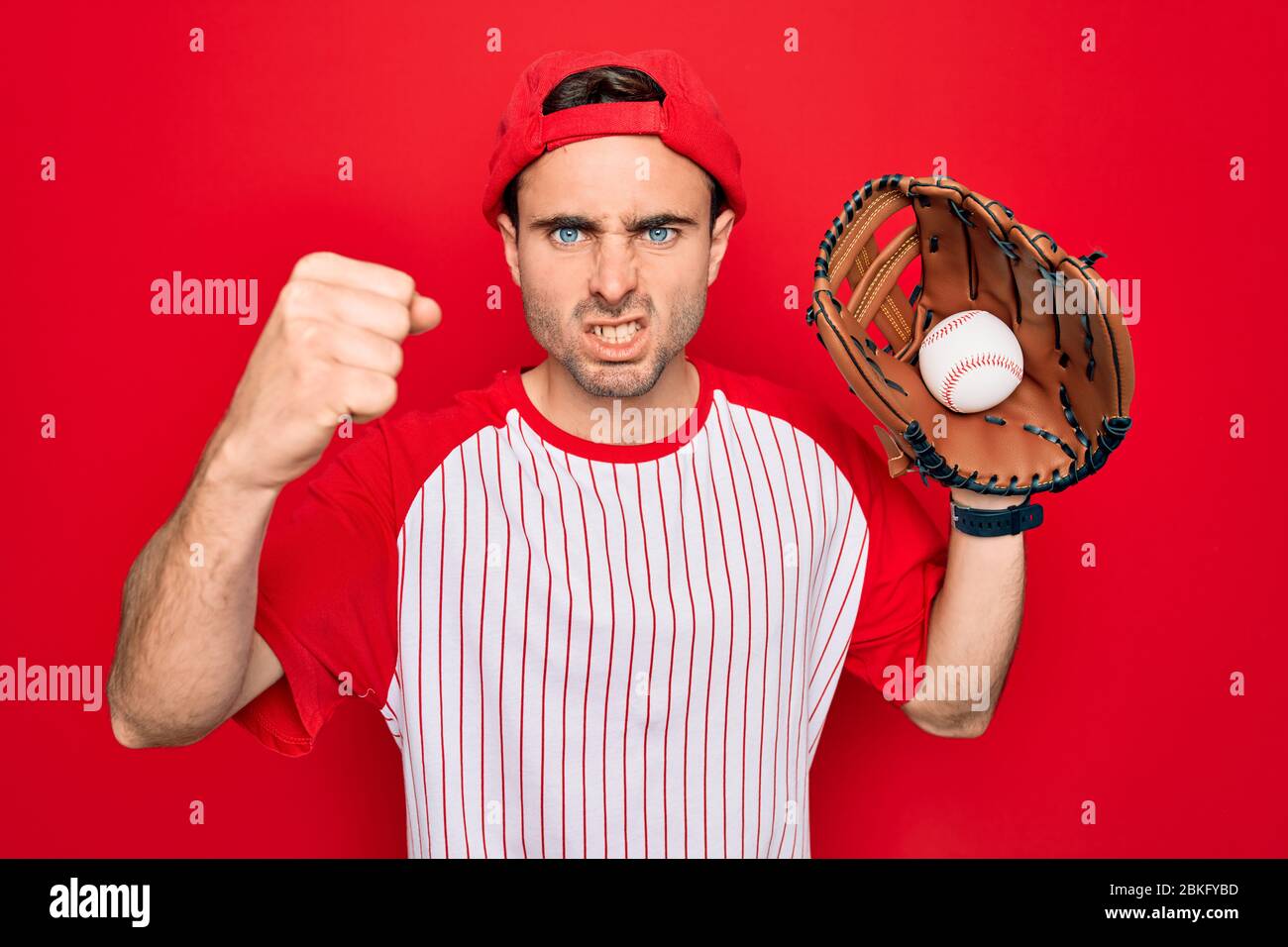 Young handsome sporty man with blue eyes playing baseball using glove ...