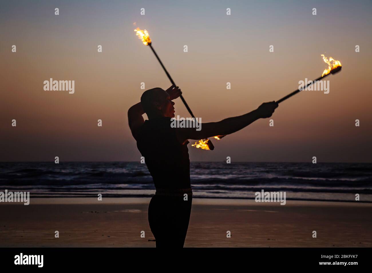 Goa, India, February 9, 2019: Fire juggler performing with fire sticks ...