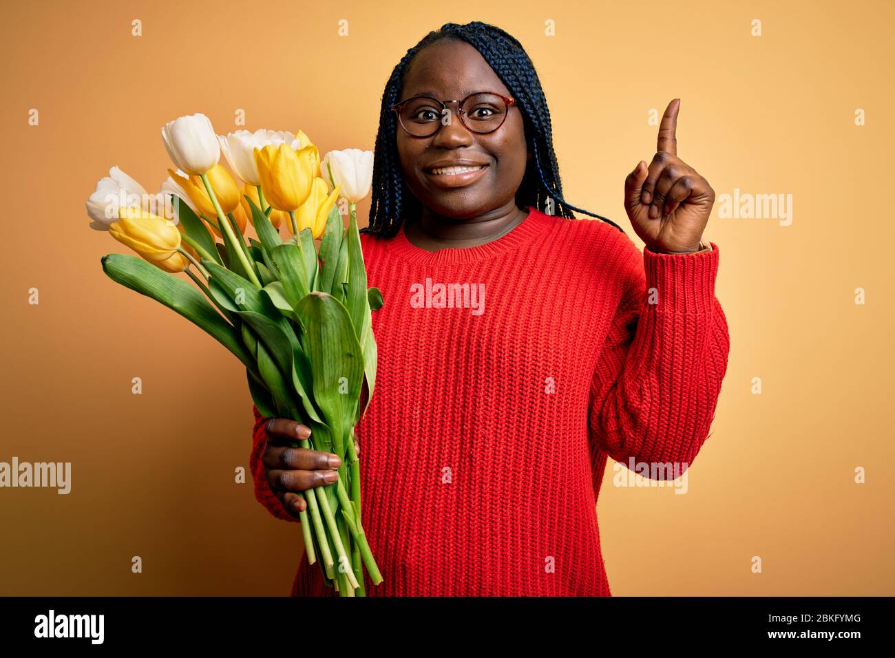Young african american plus size woman with braids holding bouquet of ...