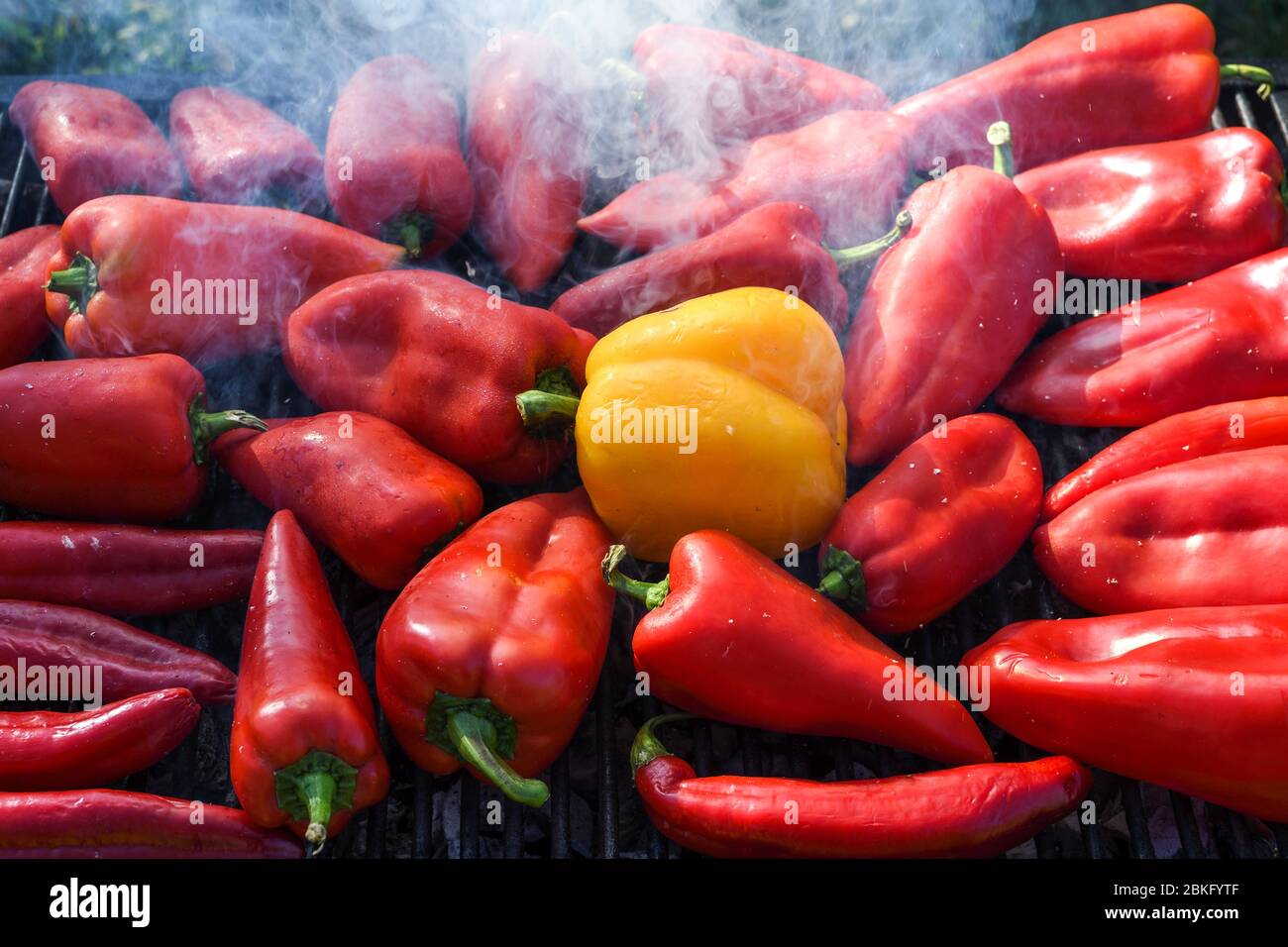 Red peppers grilling during outside outdoor BBQ or picnic. Man ...