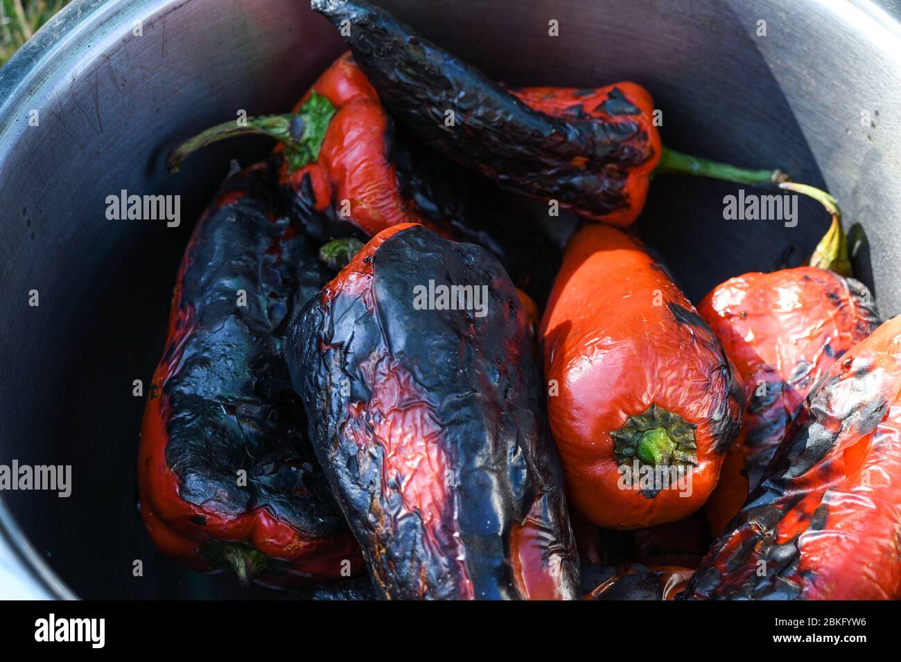 Red peppers grilling during outside outdoor BBQ or picnic. Man ...