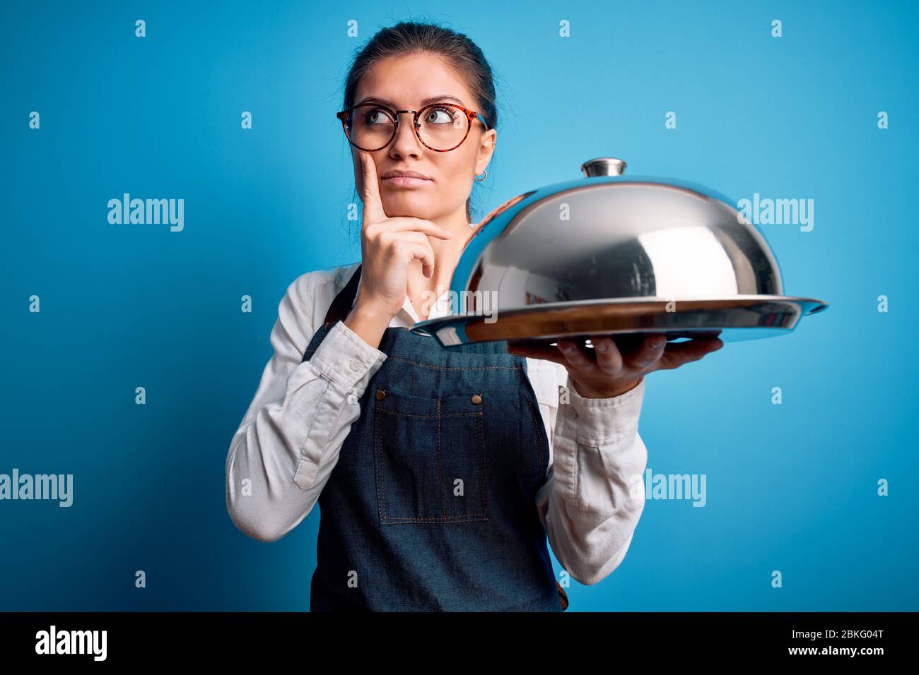 Young beautiful waitress woman with blue eyes holding tray with dome ...