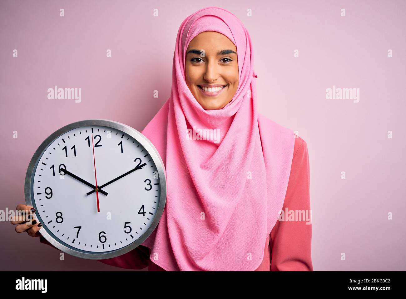 Young beautiful arab woman wearing pink muslim hijab doing countdown ...
