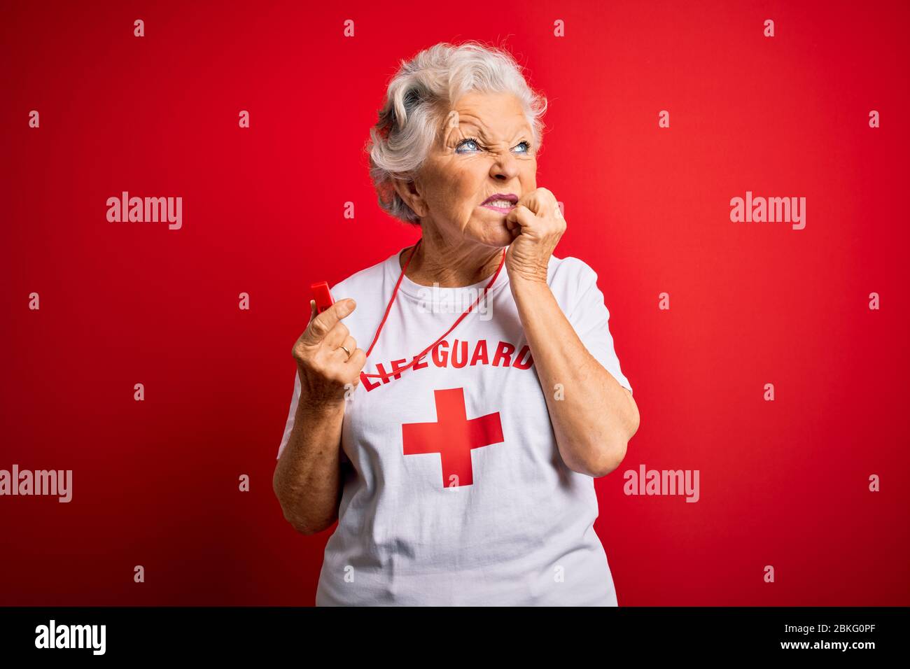 Senior beautiful grey-haired lifeguard woman wearing t-shirt with red ...