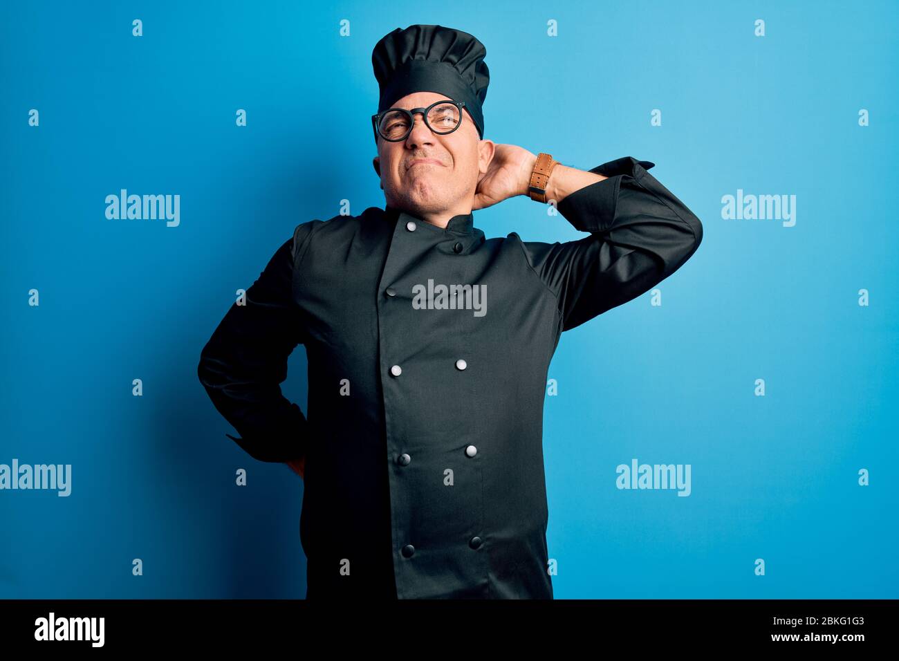 Middle age handsome grey-haired chef man wearing cooker uniform and hat ...