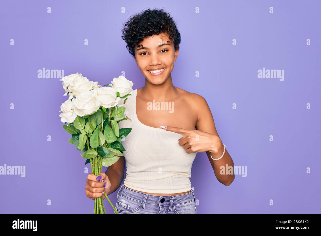 Beautiful african american afro woman holding bouquet of white flowers ...