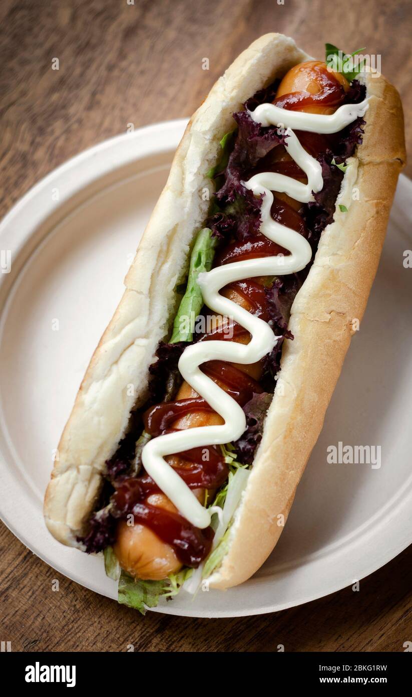 classic hot dog with frankfurter sausage and sauces on wood table Stock ...