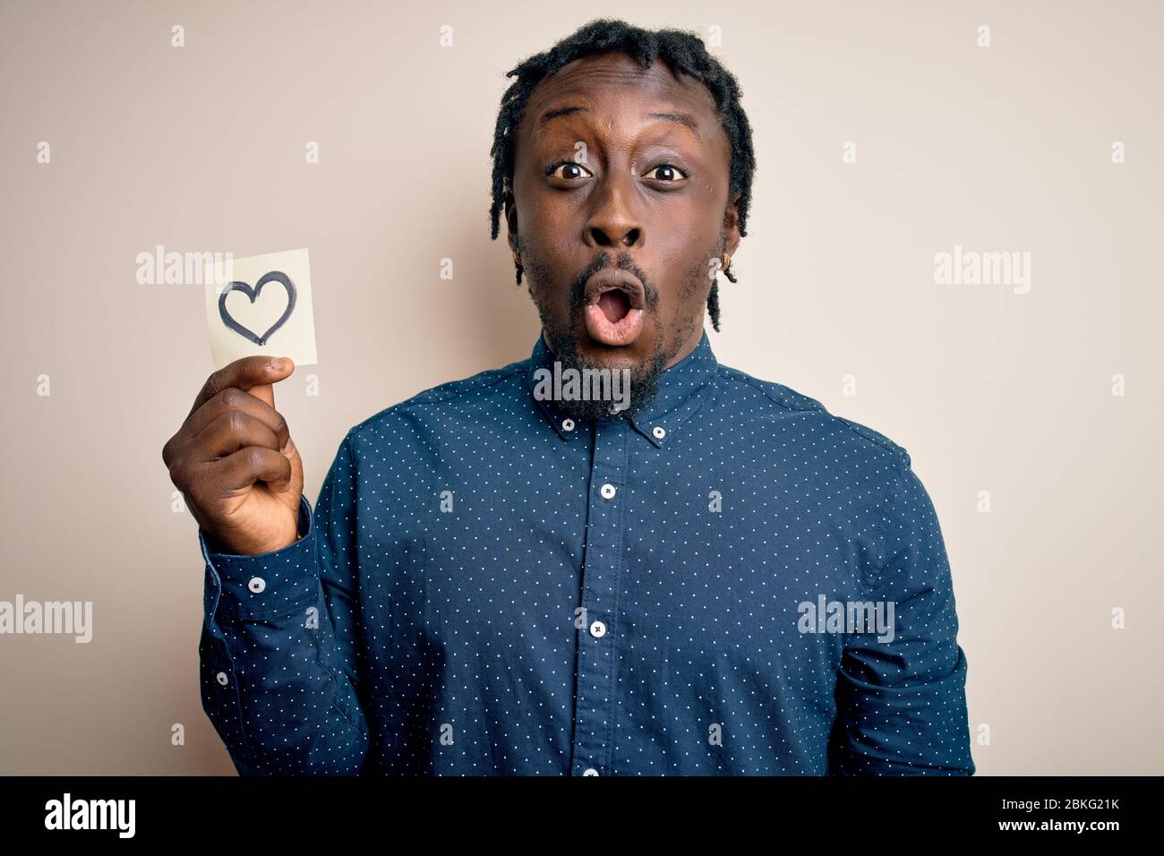African american romantic man holding reminder with heart symbol over ...